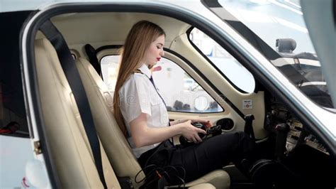 Female Pilot Performing Pre Flight Checks In Cockpit Stock Footage