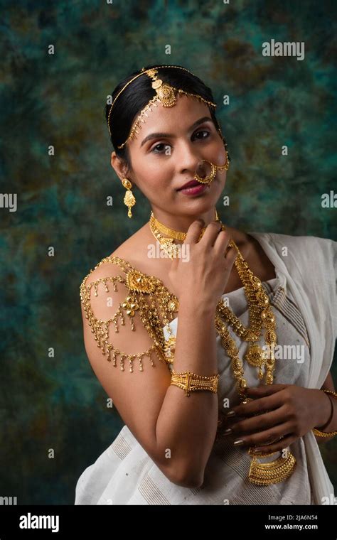 Indian Female Model Wearing A White Saree And Gold Jewellry Sporting A Bengali Traditional Saree