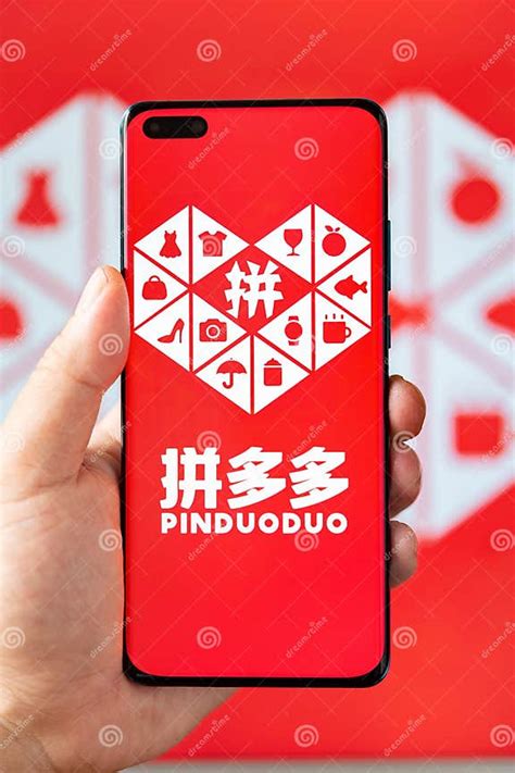Man Holding A Mobile With Pinduoduo Logo At Vertical Composition