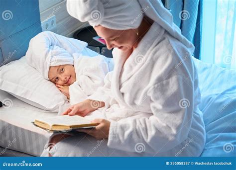 Mother Reading Book With Stories To Her Little Sleepy Daughter Stock