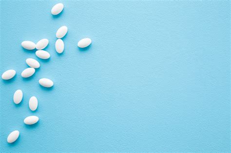 밝은 파스텔 블루 테이블에 흰색 알약 의료 약국 및 의료 개념 근접 촬영 텍스트 또는 로고가 비어 있는 장소입니다 하향하 보기