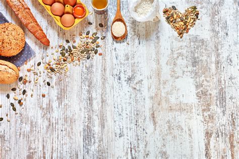 신선한 빵 Wholegrain 밀가루 올리브 오일 계란 판지 트레이 나무로 되는 숟가락 곡물과 씨앗 빛 나무 테이블에 설정