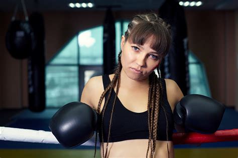 그녀의 손에 권투 장갑을 착용 한 여성 전투기는 로프에 기대어 권투 링에 서 있습니다 가방에 대한 스톡 사진 및 기타 이미지
