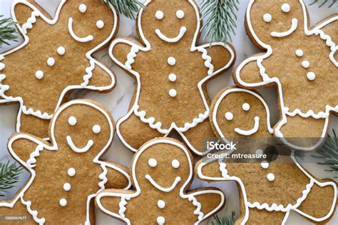 대리석 효과 배경에 가문비 나무 바늘로 둘러싸인 흰색 왕실 장식으로 장식 된 6 개의 수제 진저 브레드 남자 비스킷의 클로즈업 이미지 높은 전망 쿠키에 대한 스톡 사진 및