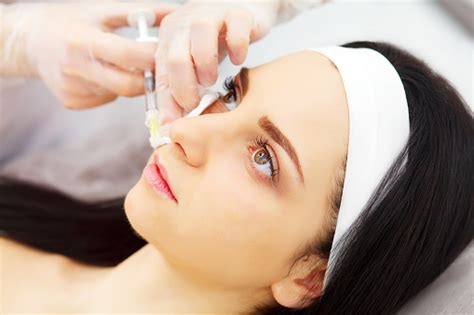 예쁜 백인 여성 얼굴 영역에 주입 히 알루 론 산의 여자의 얼굴을 콜라겐으로 채우는 주사기와 남성 의사 젊 어 짐 치료