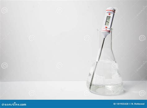 A Digital Thermometer Measuring The Temperature Of A Liquid In A Glass Erlenmeyer Flask On A