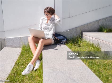 여자는 도시 공원 벤치에 노트북과 함께 앉아 직장에서 프리랜서 학생은 야외에서 원격으로 배운다 현대적인 라이프 스타일 여름 분위기 야외 작업장 공부에 대한 스톡 사진 및