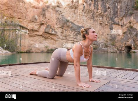 Full Body Side View Of Fit Barefoot Female In Sportswear Doing Cow Pose While Practicing Yoga