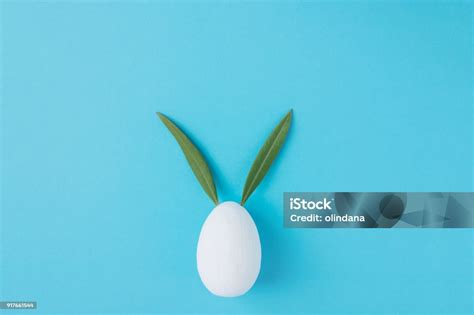 녹색 장식 흰색 페인트 빈 부활절 달걀 토끼 귀로 떠난다 파스텔 빛 파란색 배경입니다 드로잉 다른 귀여운 얼굴 표정까지 비웃는