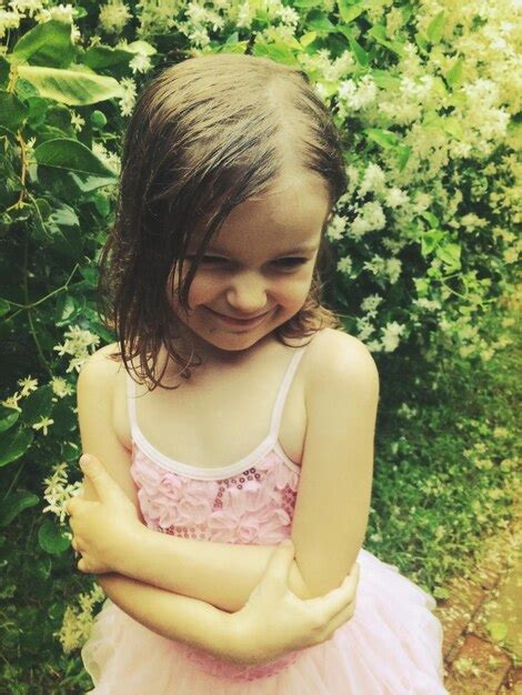 Premium Photo Close Up Of Smiling Girl Standing By Plants