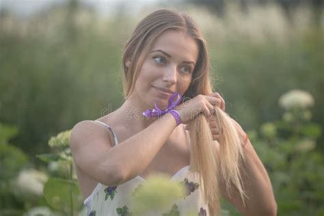 Молодая красивая женщина в теплых лучах солнца вечера идя на зеленое
