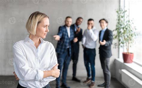 Sexism And Bullying At Work Unhappy Victimized Business Lady Standing While Her Male Coworkers