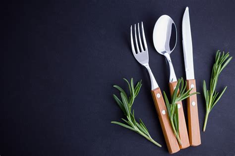 칼 세트입니다 칼 숟가락 어두운 배경에 포크 로즈마리를 곁들인 크립토클러리 검은 색 배경입니다 테이블 설정 맨 위 보기 0명에 대한 스톡 사진 및 기타 이미지 Istock