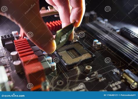 technician plug in cpu microprocessor to motherboard socket workshop background pc upgrade or