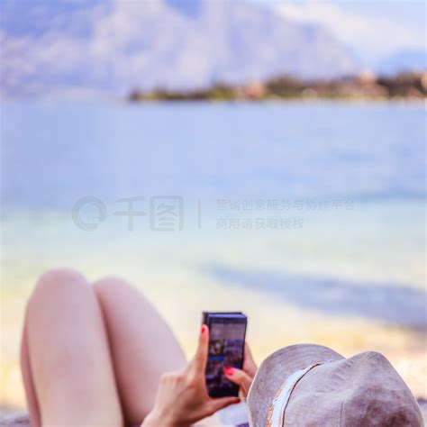 比基尼高清图片 暑假漫游：穿比基尼的年轻女孩正在意大利海滩上使用智能手机 风景名胜免费下载 格式 4160像素 编号43537969 千图网