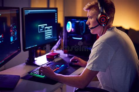 Male Teenage Hacker Sitting In Front Of Computer Screens Bypassing