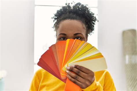 African American Woman Covering Mouth With Color Test At New Home Stock