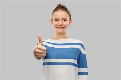 Улыбающаяся девочка подросток показывает большой палец Премиум фото