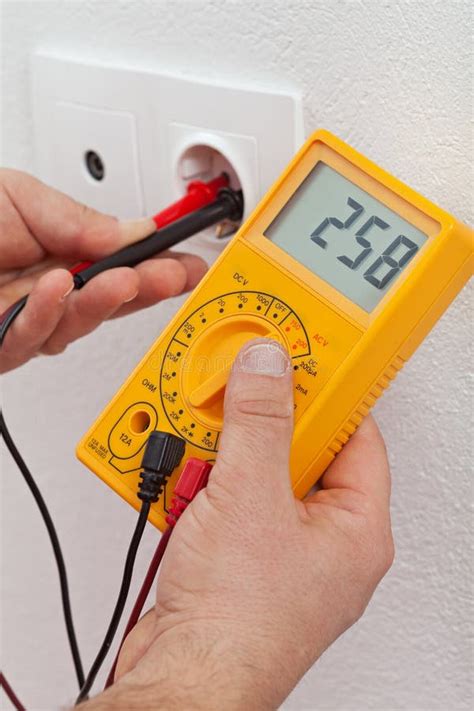 Electrician Hands Measuring Voltage In Electrical Outlet Stock Image