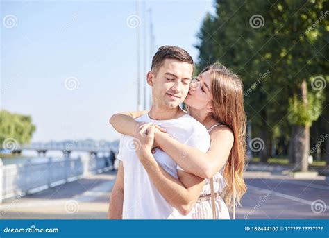 Pretty Blond Woman Kissing And Hugging Handsome Brunette Guy From The