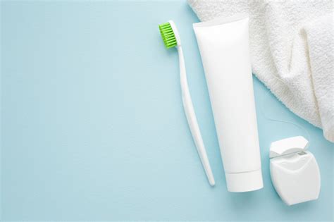치약의 흰색 튜브 녹색 털이 있는 칫 솔 치 실을 용기와 파스텔 파란색 배경에 수건 사람들 치아 위생 개념입니다 텍스트 인용 격언 또는 로고에 대 한 빈 장소 솔질에 대한