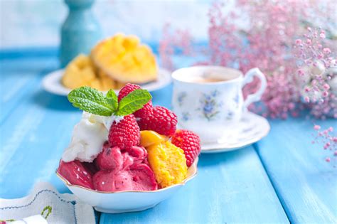 망고 딸기와 민트 블루 나무 배경에 접시에 밝은 색상의 아이스크림 모닝 커피와 빛과 꽃의 컵 빈티지 사진입니다 배너입니다 공간 복사 강판에 갈기에 대한 스톡 사진 및 기타