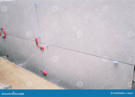 Installation Of Porcelain Tiles On The Wall Tile Leveling System Stock