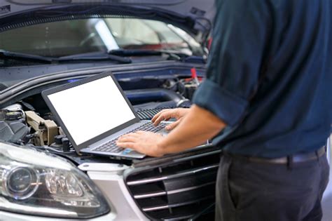 노트북으로 자동차에서 일하는 유니폼을 입은 잘생긴 정비사 직업 노트북에서 가까운 전망 35 39세에 대한 스톡 사진 및 기타 이미지 35 39세 거라지 세일 검사