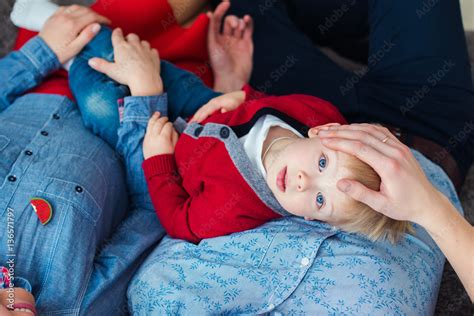 Foto Stock мальчик лежит на кровати с родителями Adobe Stock