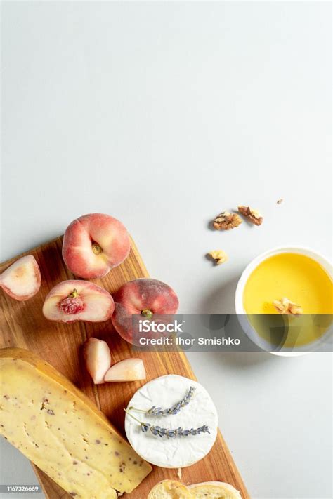 나무 도마에 치즈의 다른 유형을 볼 상단 무화과 복숭아 꿀 시아바타와 견과류 레드 와인 한 잔을 곁들인 치즈 세련된 음식 플랫 회색 배경에 누워 공간을 복사합니다 소프트