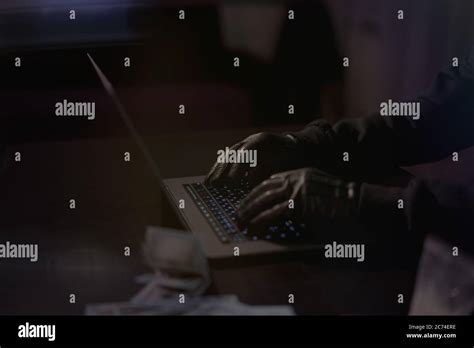 Male Hacker In The Hood In A Dark Room Using Computer Virus Program For Cyber Attack Hackers