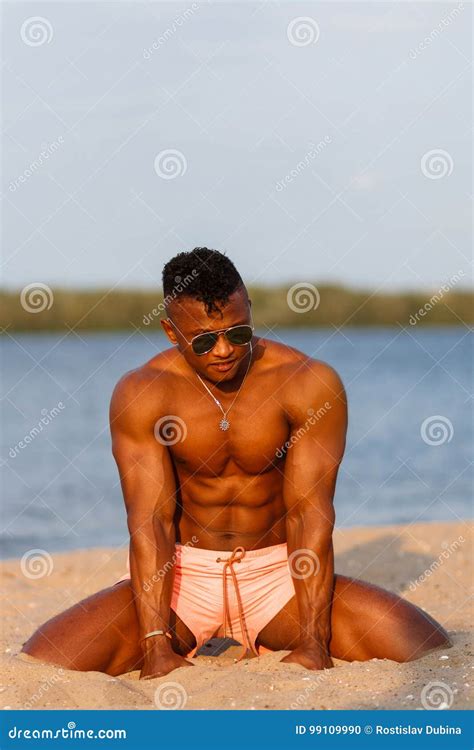 Muscular Young Athletic Man On The Beach With A Naked Torso In