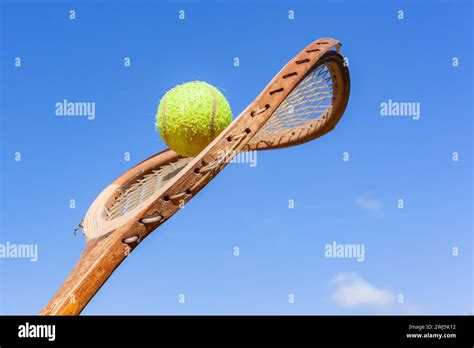 Old Tennis Racket Bent Twisted Frame With Ball Attached Closeup Blue Sky Sports History