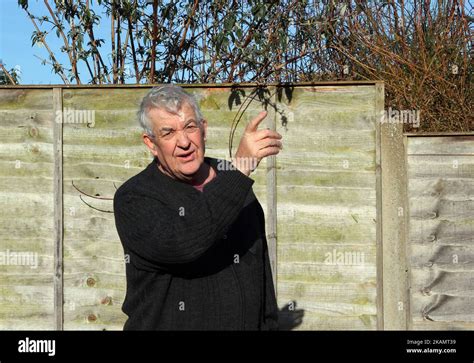 Senior Man Looking Towards The Camera And Pointing Direction Either
