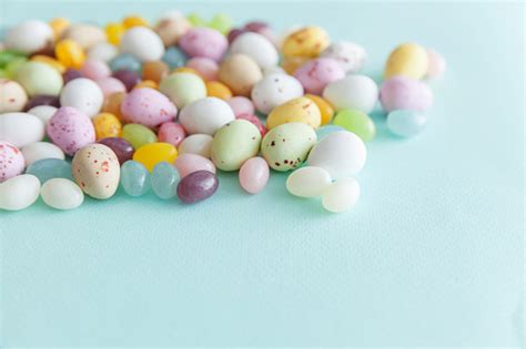 행복 한 부활절 개념입니다 휴가 준비 부활절 사탕 초콜릿 달걀과 젤리 빈 과자 트렌디 한 파스텔 블루 배경에 고립 간단한