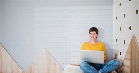 집 실내 침실의 침대에 노트북을 들고 있는 젊은 여성의 전면 모습 공간을 복사합니다 사진 Unsplash의 슬로바키아 이미지