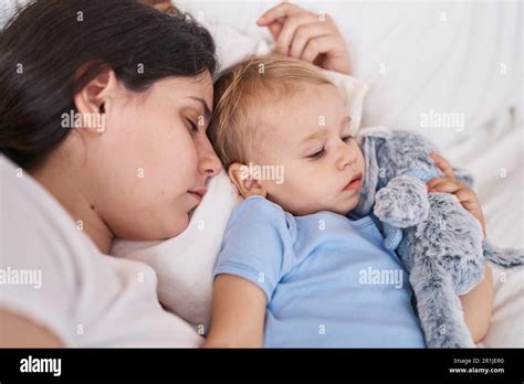 Mother And Son Sleeping On Bed Hugging Doll At Bedroom Stock Photo Alamy