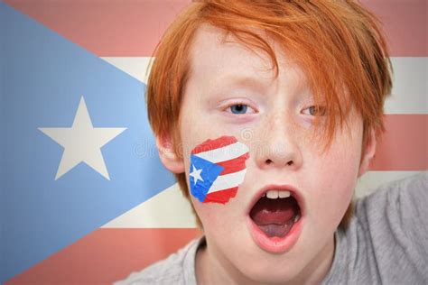 Мальчик вентилятора Redhead при флаг Puerto Rican покрашенный на его