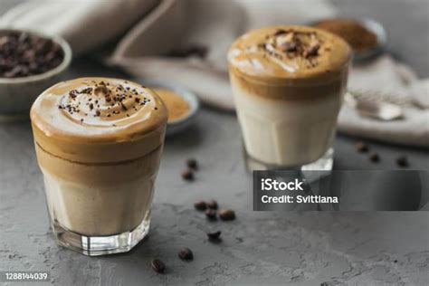 달고나는 커피 인스턴트 크림 아이스 커피를 휘핑했다 회색 배경 모형에 커피 우유 얼음 큐브와 칵테일 텍스트복사 공간이 있는