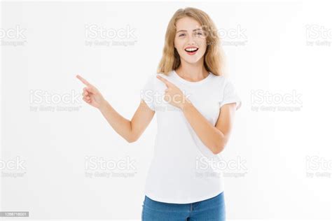 흰색 템플릿과 빈 배경에 고립 된 손가락으로 복사 공간을 가리키는 여름 티셔츠를 입은 젊은 금발 백인 여성의 초상화 충격과 흥분 얼굴 20 24세에 대한 스톡 사진 및 기타