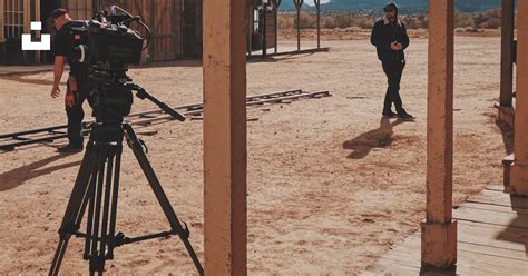 검은 재킷과 바지를 입은 남자가 전문 비디오 카메라 녹화 앞에 서 있습니다 사진 Unsplash의 무료 산타페 이미지