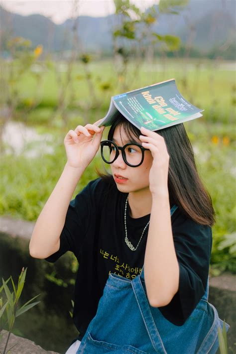 검은 크루넥 티셔츠를 입은 여자가 파란색과 흰색 책을 들고 있다 사진 Unsplash의 무료 혼자 이미지