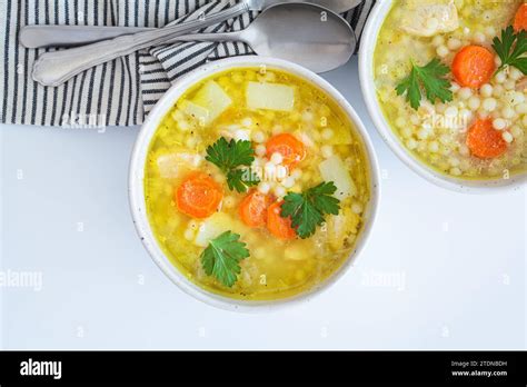 Soupe de poulet aux légumes et ptimtim couscous israélien fond blanc