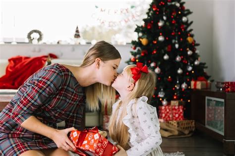 Mãe Beijando Sua Filha No Natal Foto Grátis