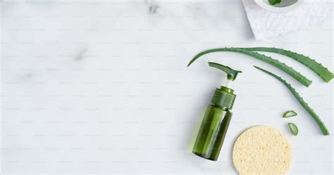 천연 유기농 화장품 로션 병 스폰지 및 얇게 썬 줄기 알로에 베라가 대리석 배경에 있습니다 플랫 레이 평면도 스킨 케어 스파 뷰티 트리트먼트 개념 사진