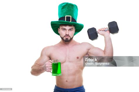 성 패트릭의 날 초록색 모자를 쓴 근육질의 남자가 에일 맥주 검은 아령을 들고 있다 격리 된 흰색 배경입니다 아 Bs St
