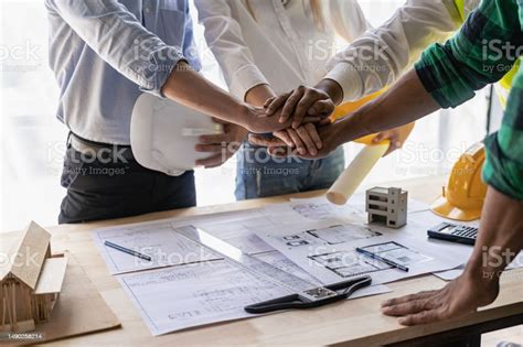 헬멧과 조끼를 든 건설 노동자들이 악수하고 있다 부동산 개념 건축가는 엔지니어 또는 건축업자 계획 및 성공적인 회의와 악수합니다