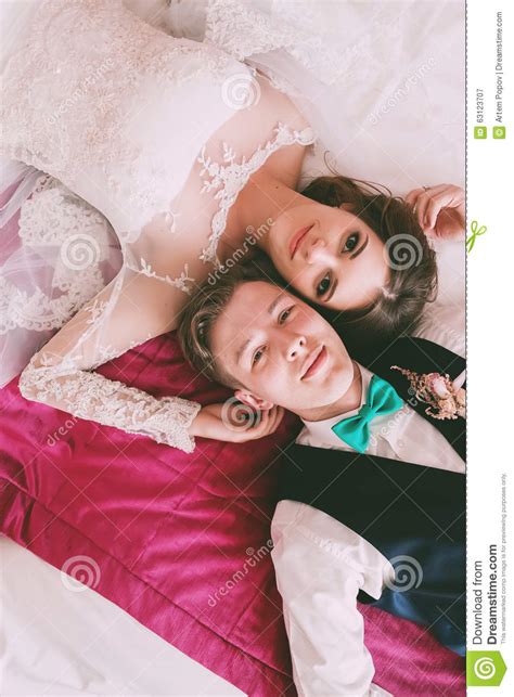 Happy Bride And Groom Lying On Violet Bed Stock Image Image Of Dress