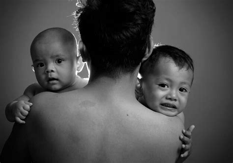 Premium Photo Rear View Of Shirtless Father Carrying Son Against Gray