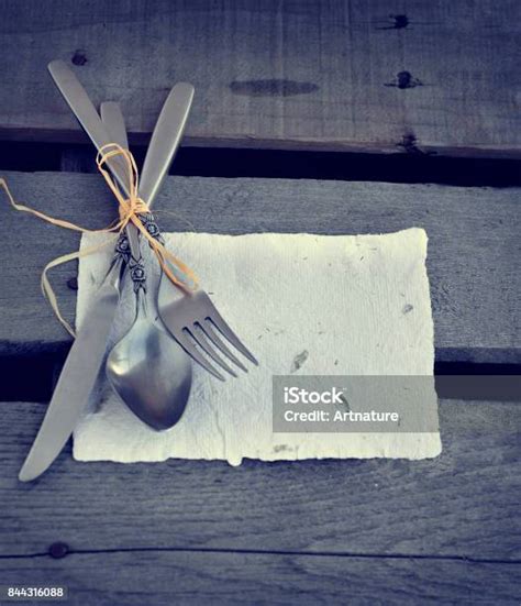 소박한 나무 바탕에 빈티지 주방 용품입니다 포크 스푼 및 나이프 복사 공간으로 흰 종이 자연 측면효과 대 한 조명에 아름 다운